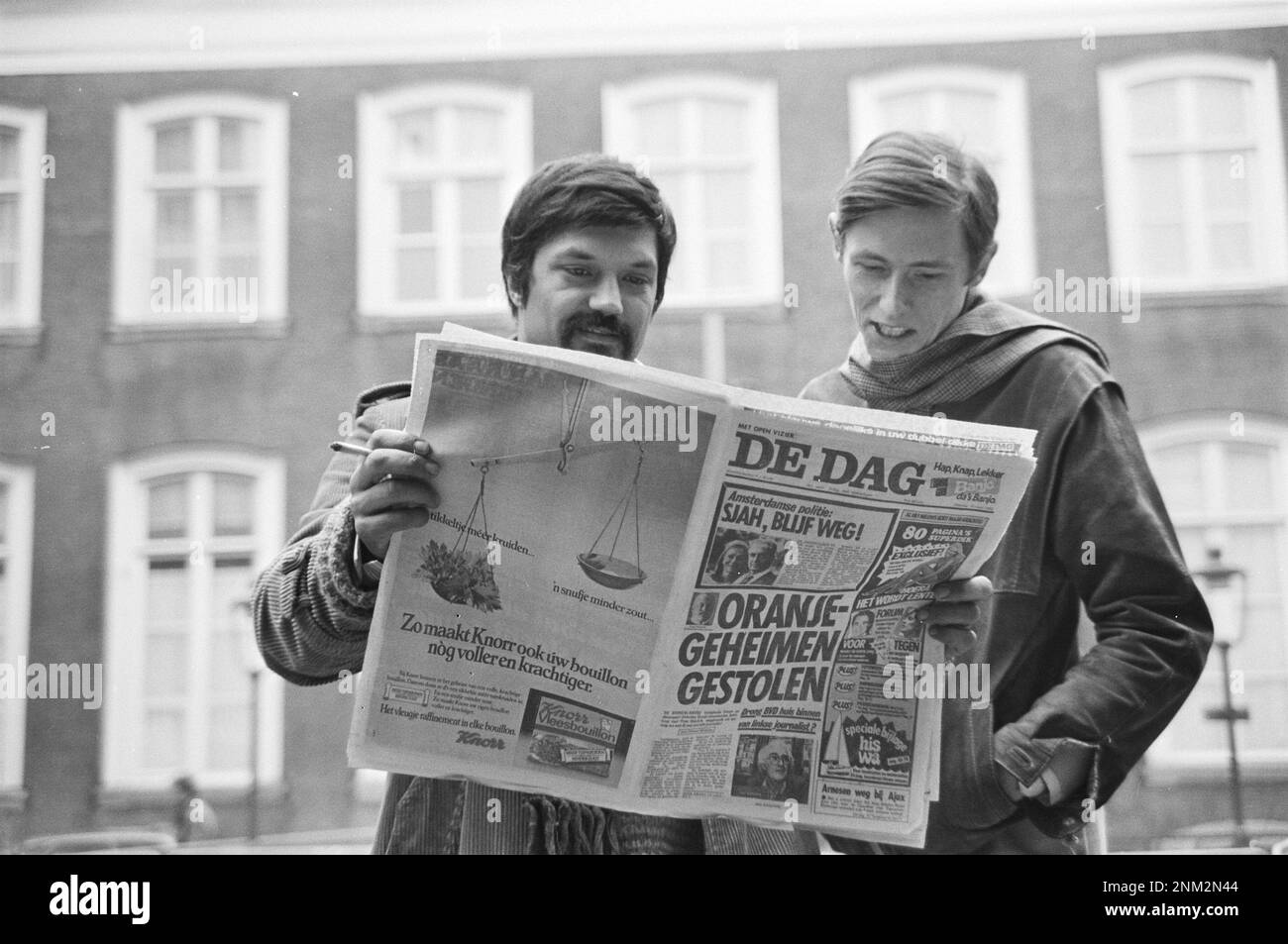 Netherlands History: Two men in the street reading the premiere edition ...