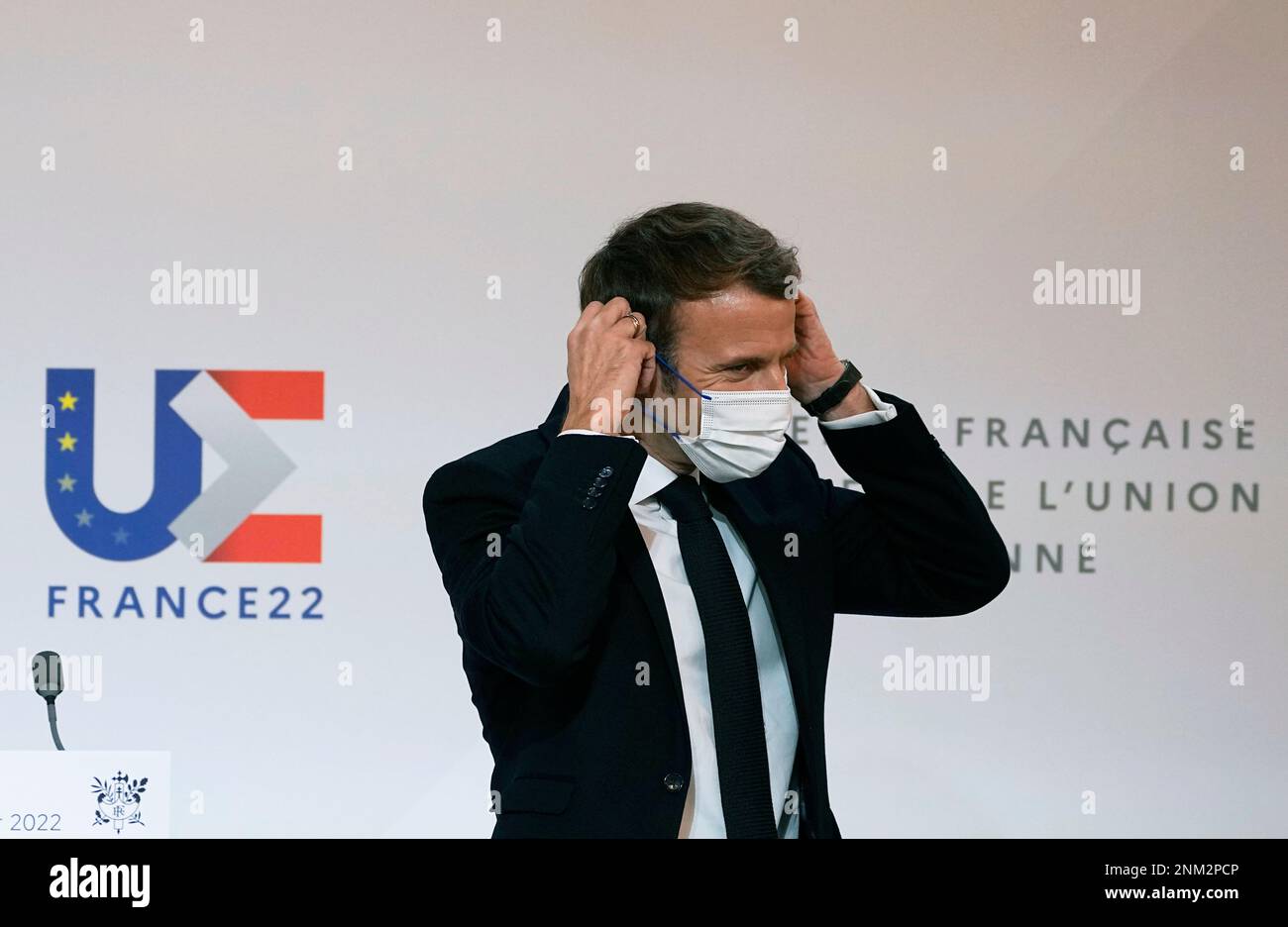 French President Emmanuel Macron puts on his protective mask after ...