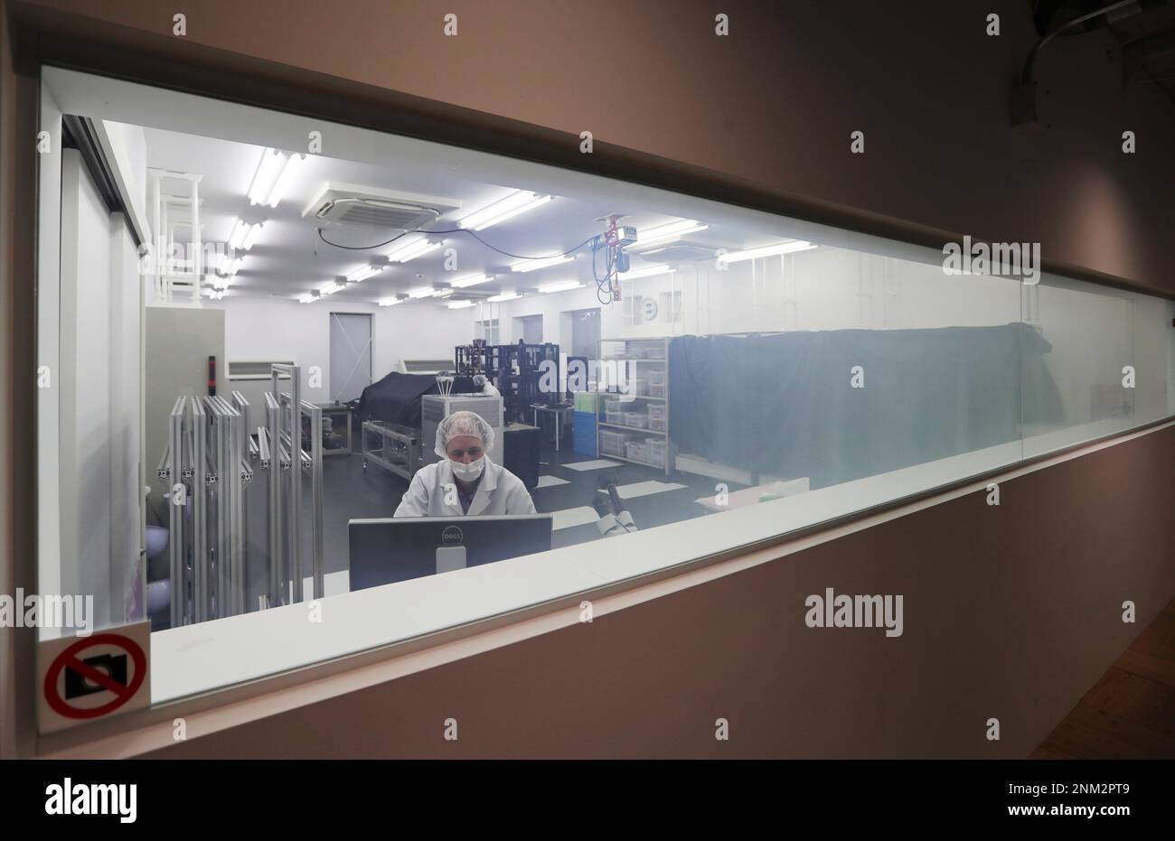 Engineers assemble a small satellite in a clean room in Chuo Ward ...