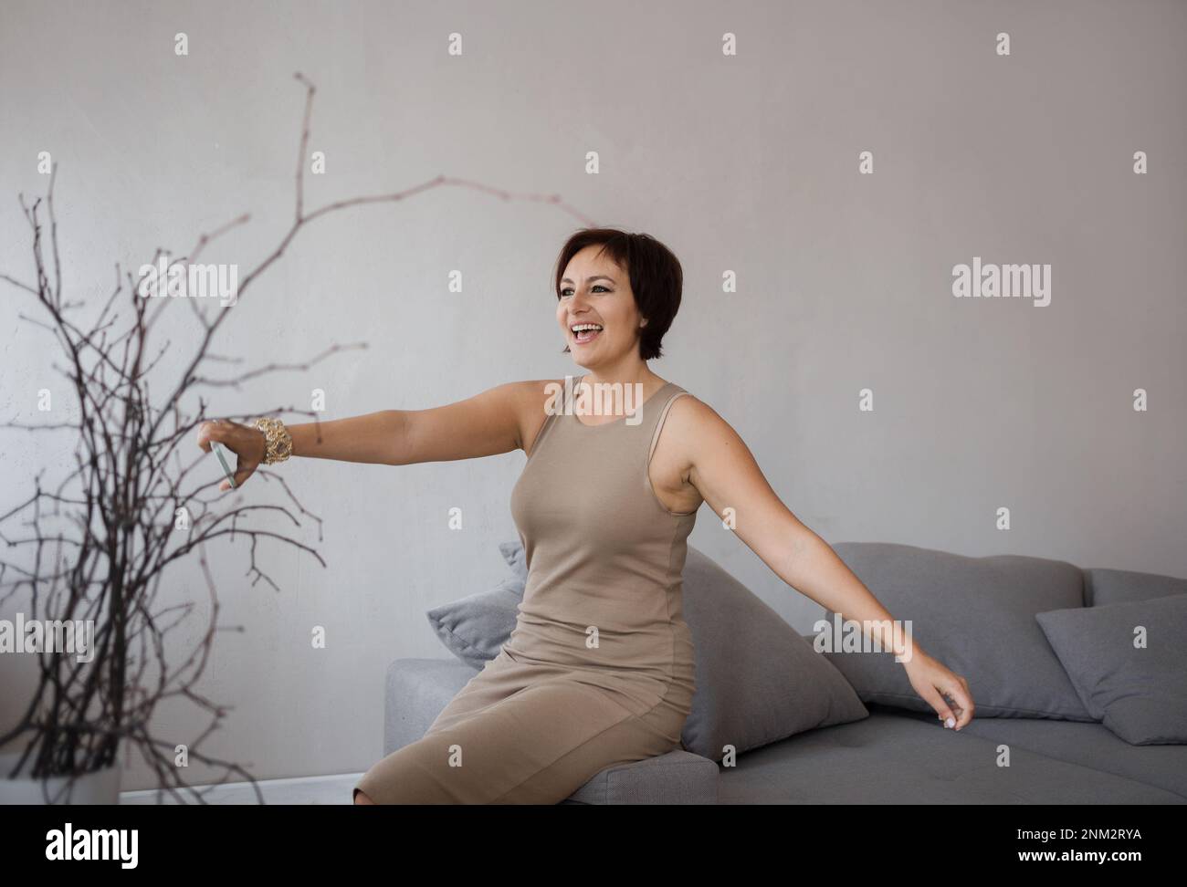 happy, contented beautiful woman over 30 in a tight dress, happily ...