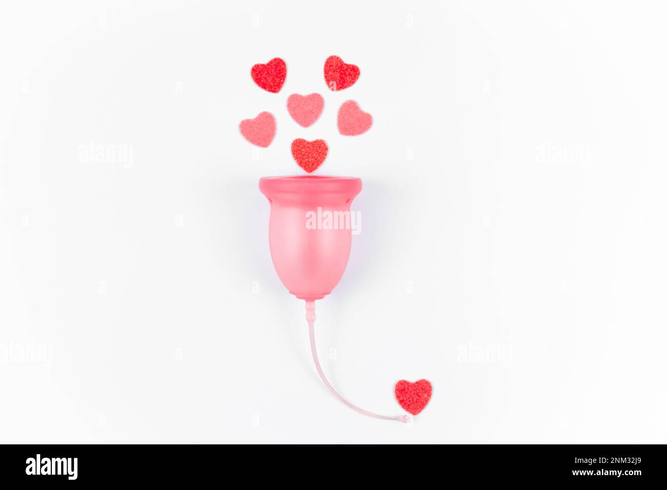 Pink menstrual cup with red hearts on white background. Alternative ...