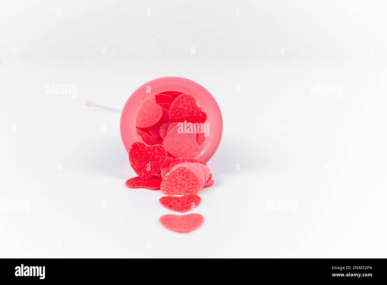 Pink menstrual cup full of small red hearts simulating bleed ...