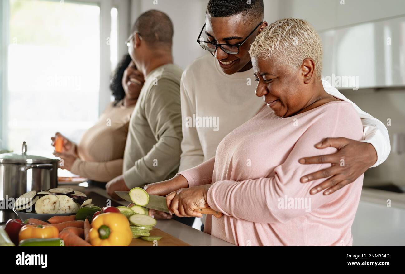Happy African family preparing food recipe together in modern kitchen ...