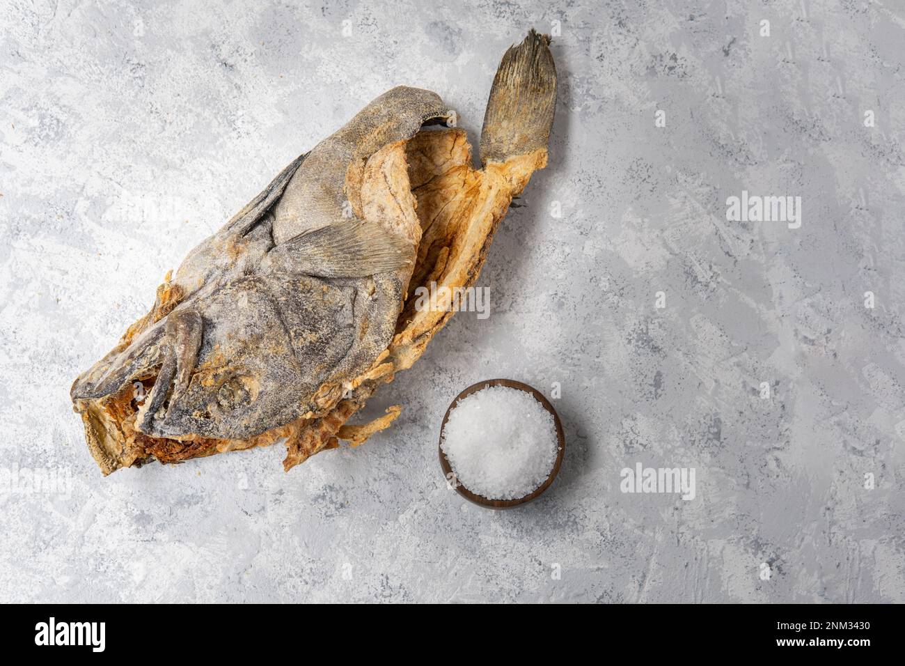 Top view of a fish preserved in salt with a well of sea salt in a ...