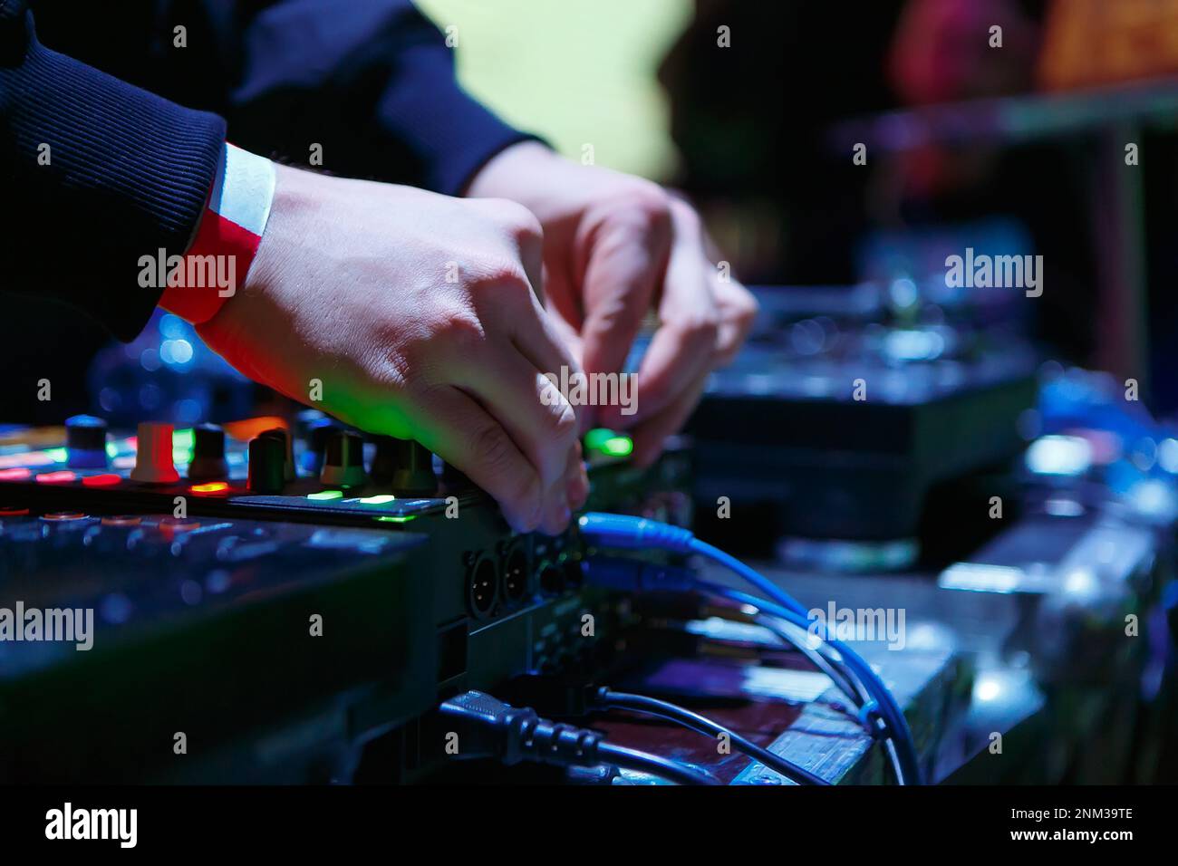 Club DJ adjusting sound mixer on stage. Professional disc jockey ...