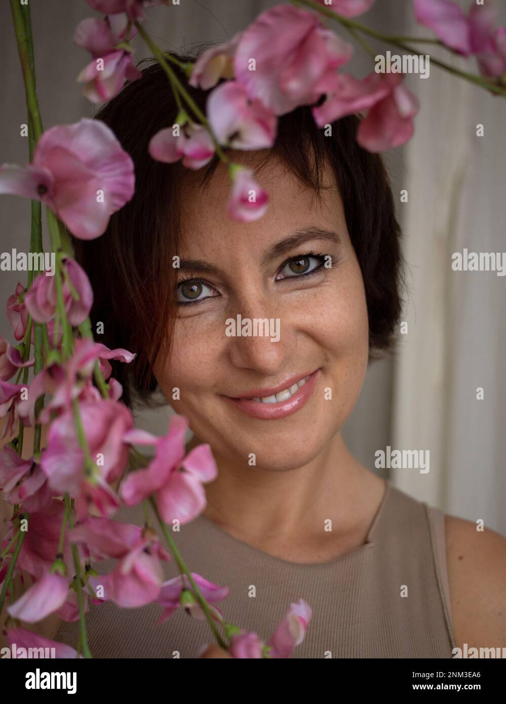 Portrait of beautiful woman's face with charming smile, near twigs in ...
