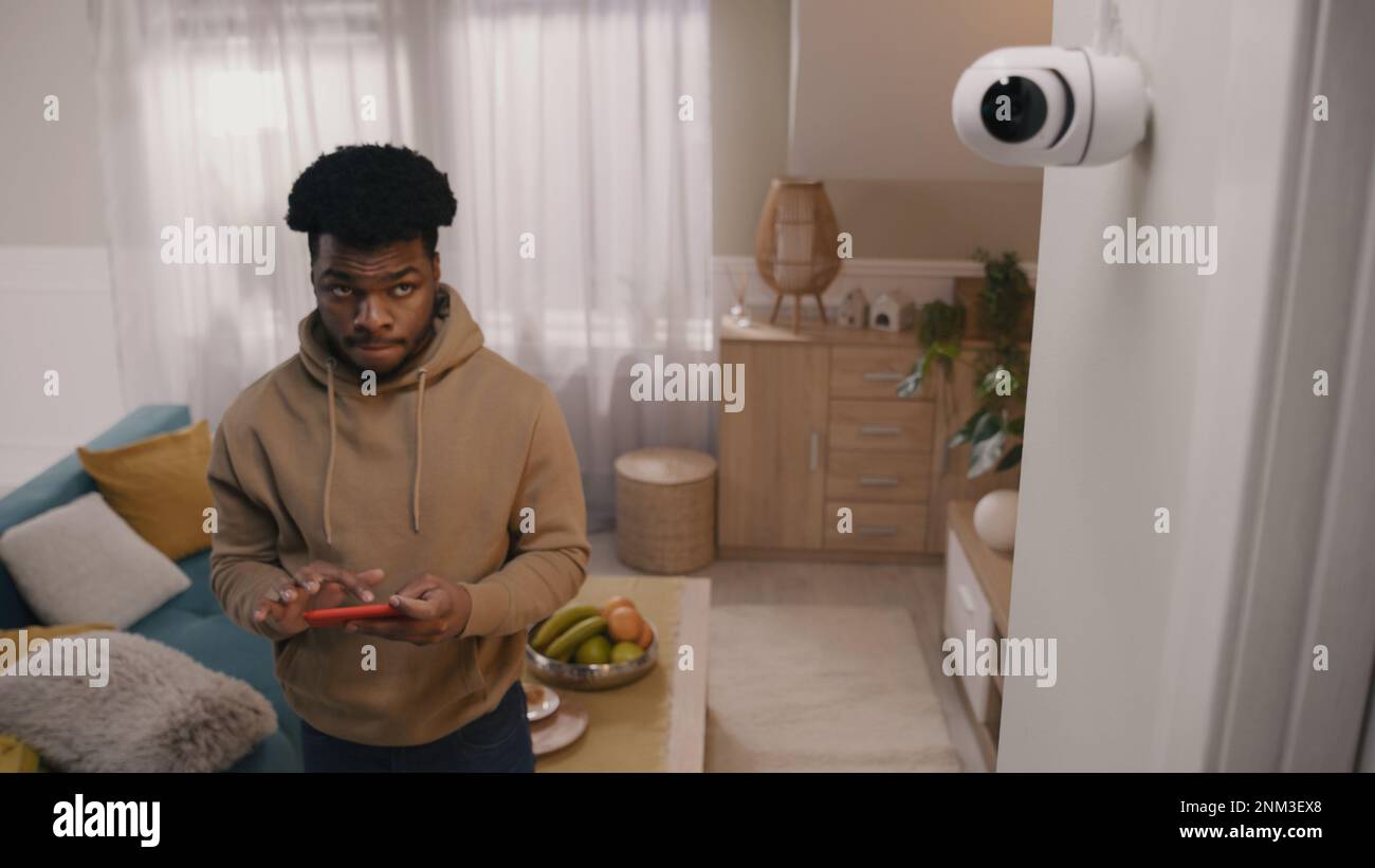 African American man completes installation of security camera. Man ...