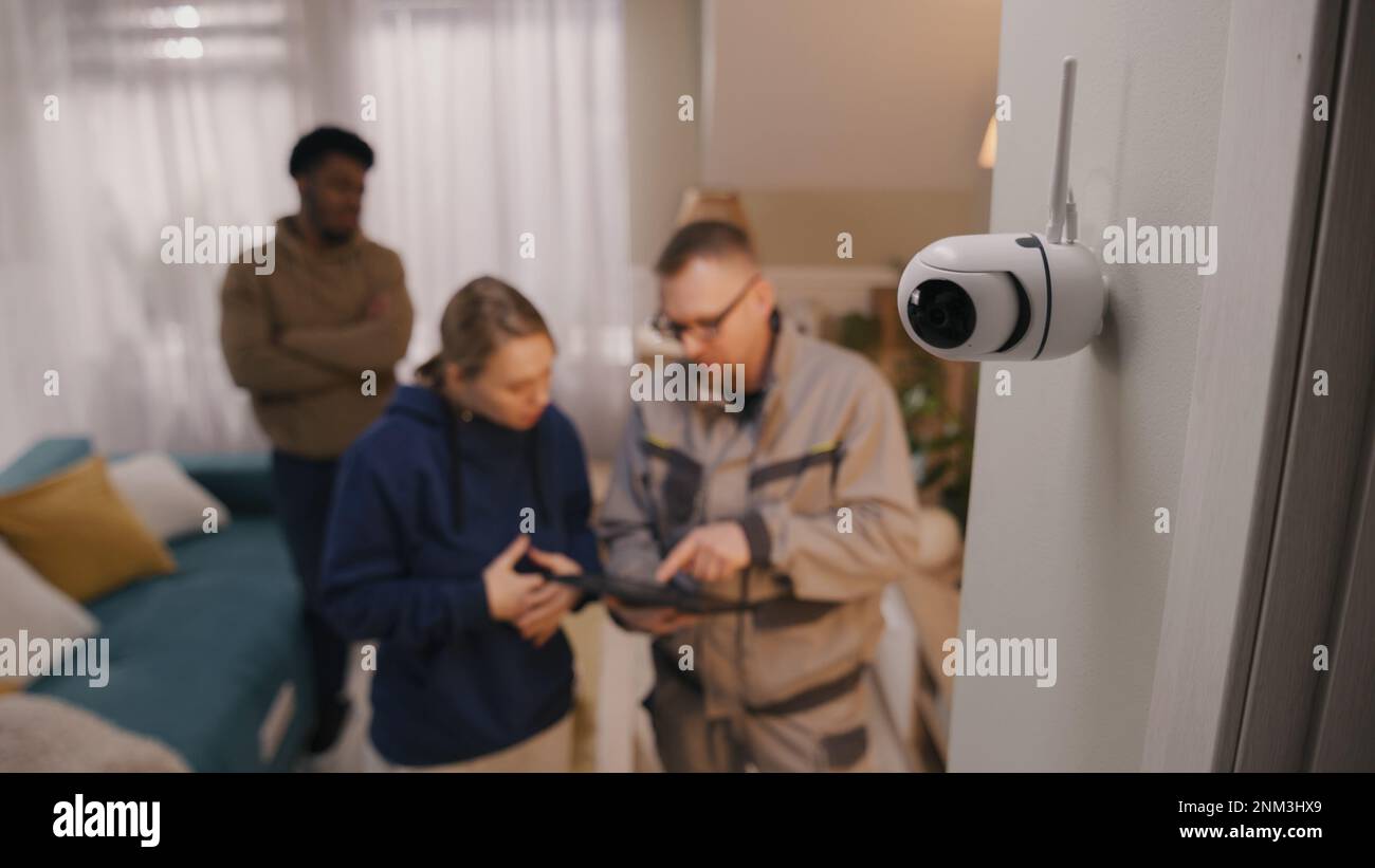 Installer sets up security camera at home of multi ethnic family using ...