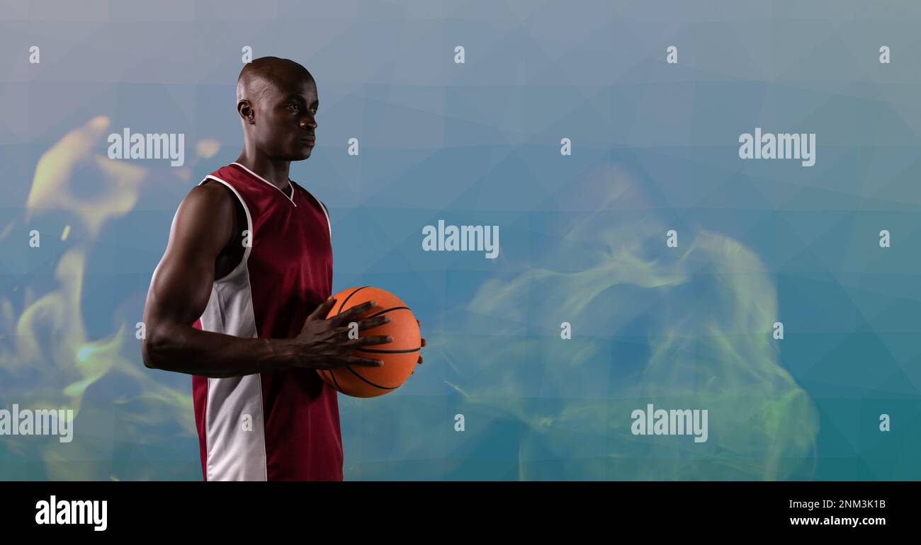 Composition of male basketball player standing holding ball, over smoke ...