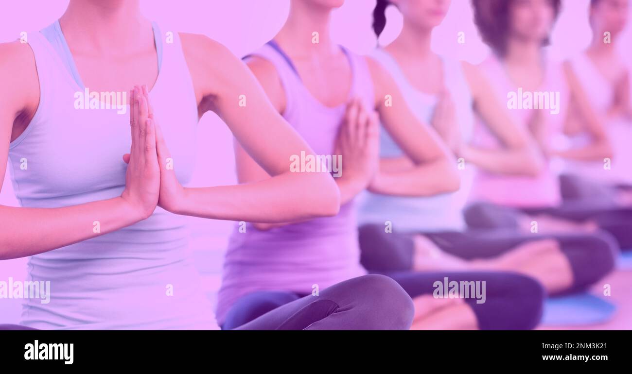 Midsection of women practicing yoga on pink background. healthy ...