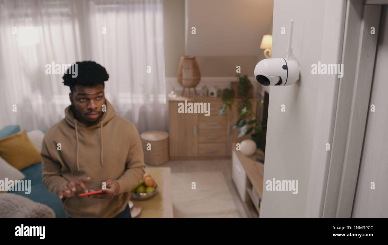 African American man completes installation of security camera. Man ...