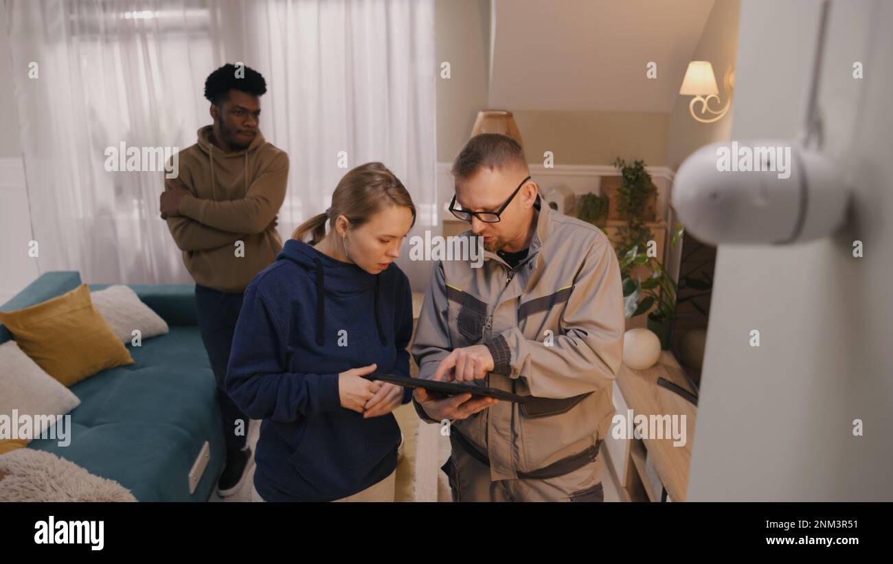 Installer sets up security camera at home of multi ethnic family using ...