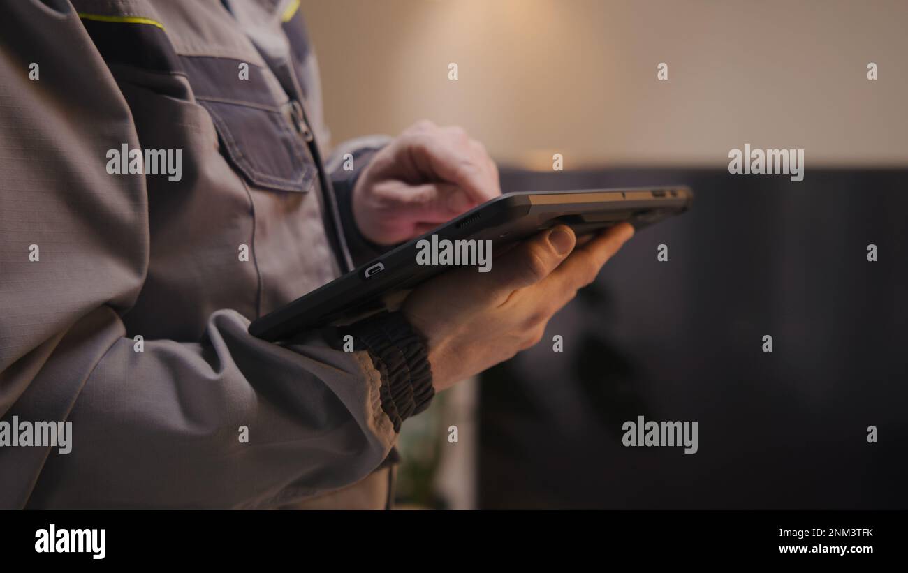 Close up shot of installer sets up security camera in house using ...