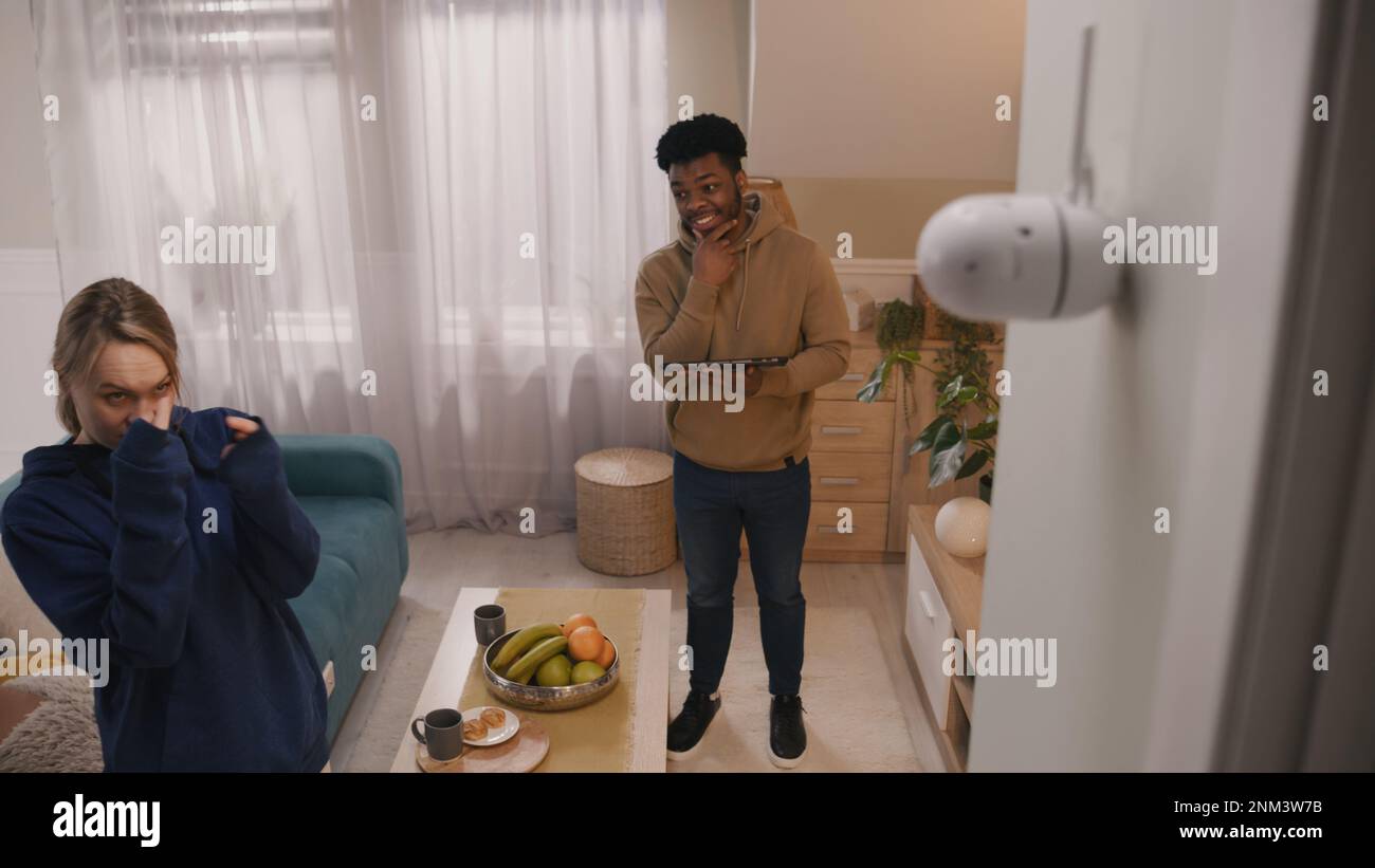 Multi ethnic couple install and set up security camera. Woman moves to ...