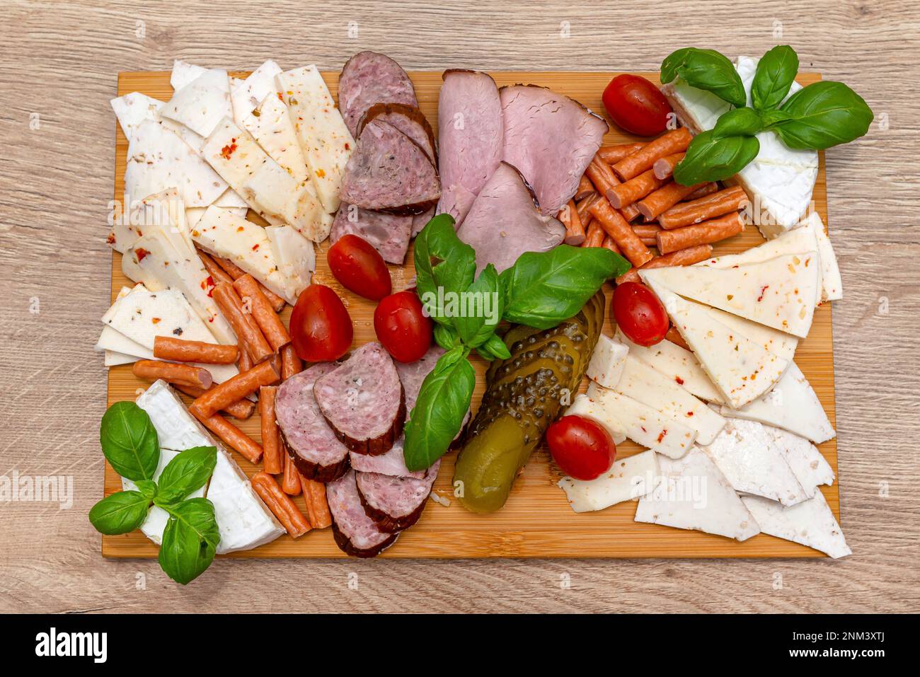 Wooden board with pieces of meat, feta cheese and vegetables, on the ...