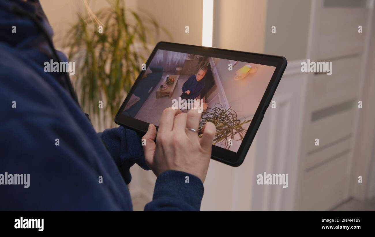 Caucasian woman checks security camera after installation. Woman sets ...