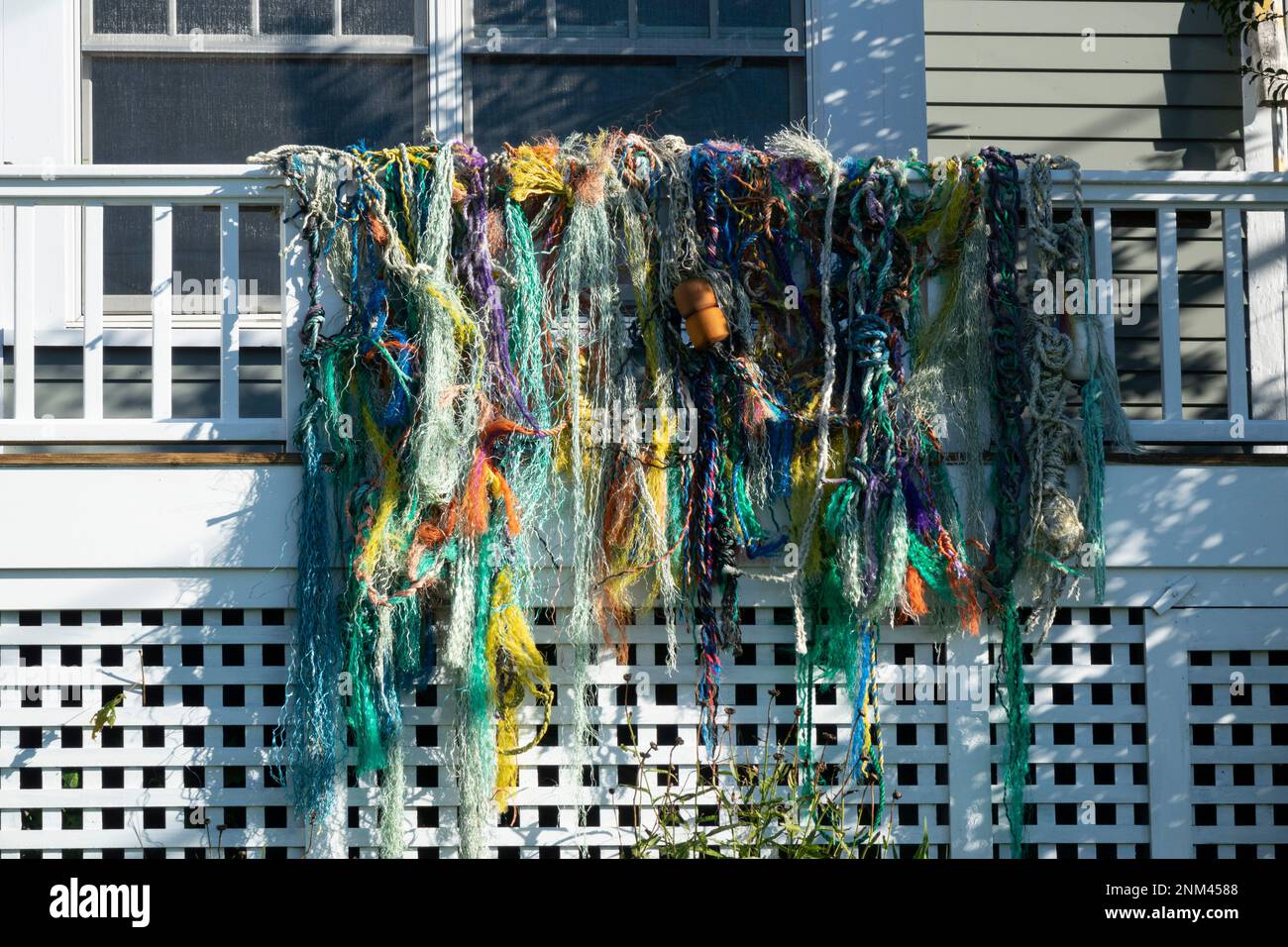 Assorted nets and floats draped over porch railing in Stonington Maine ...