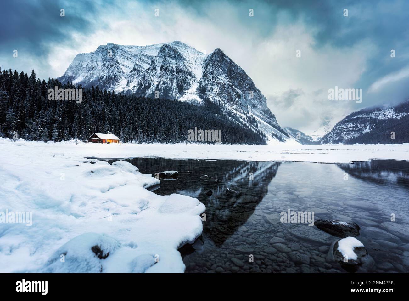 Beautiful scenery of Lake Louise with wooden cottage glowing and rocky ...