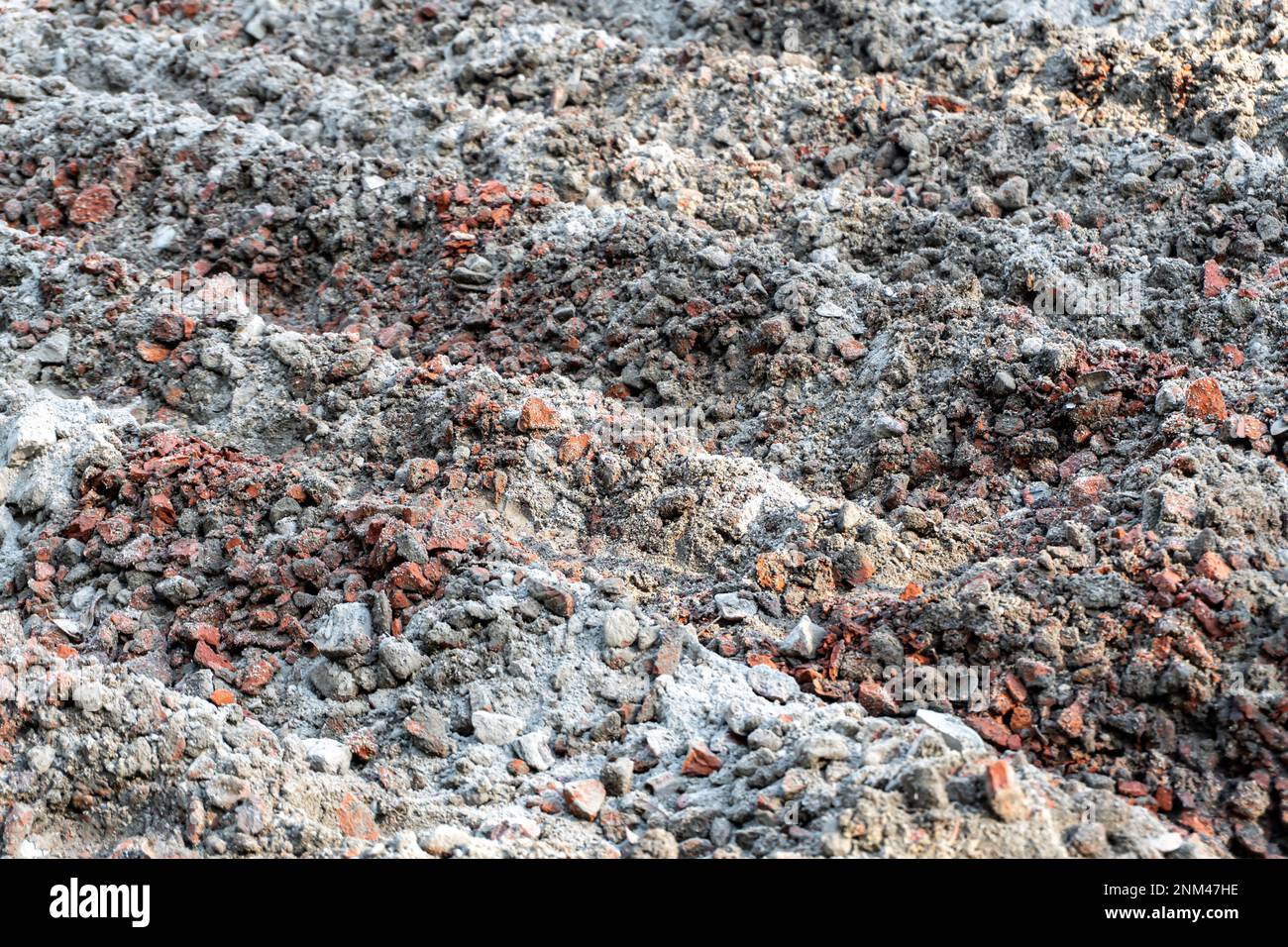 Cement powder mixed with sand, water and broken bricks. Manualy mixing ...