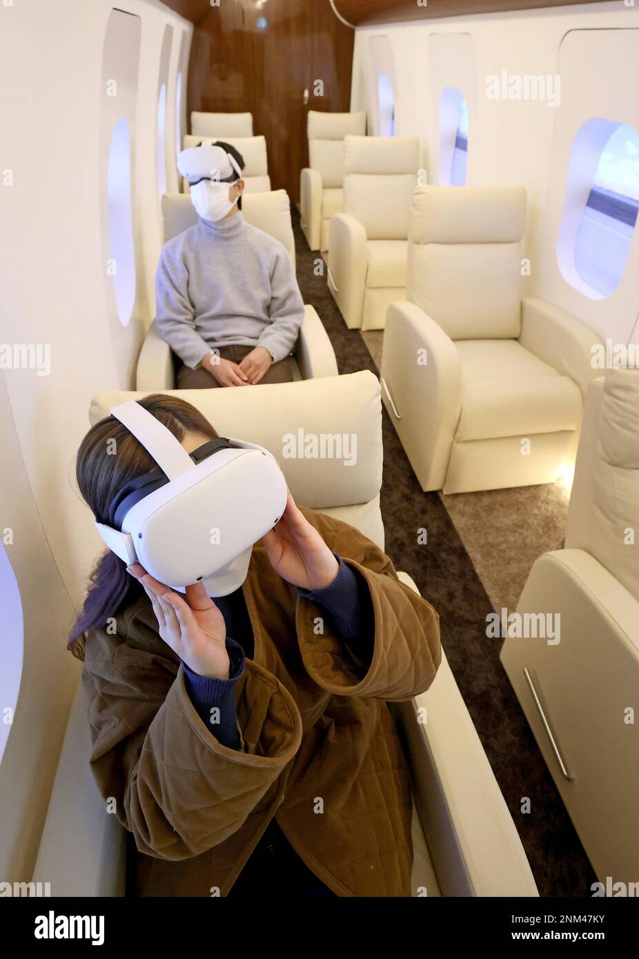 People wearing VR goggles enjoy traveling abroad at FIRST AIRLINES in ...