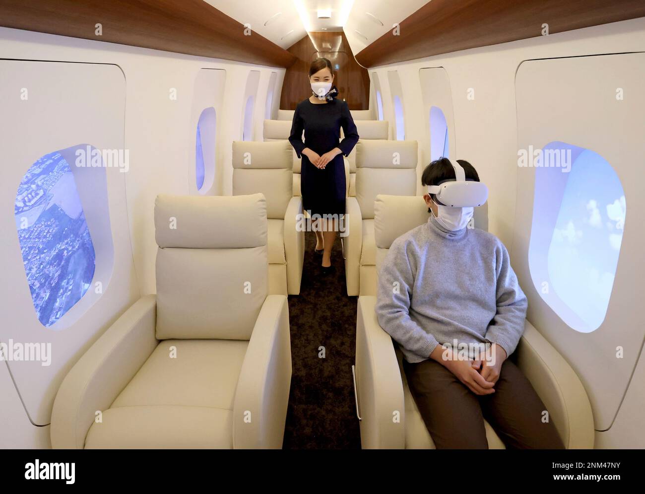 A man wearing VR goggles enjoys traveling abroad at FIRST AIRLINES in ...