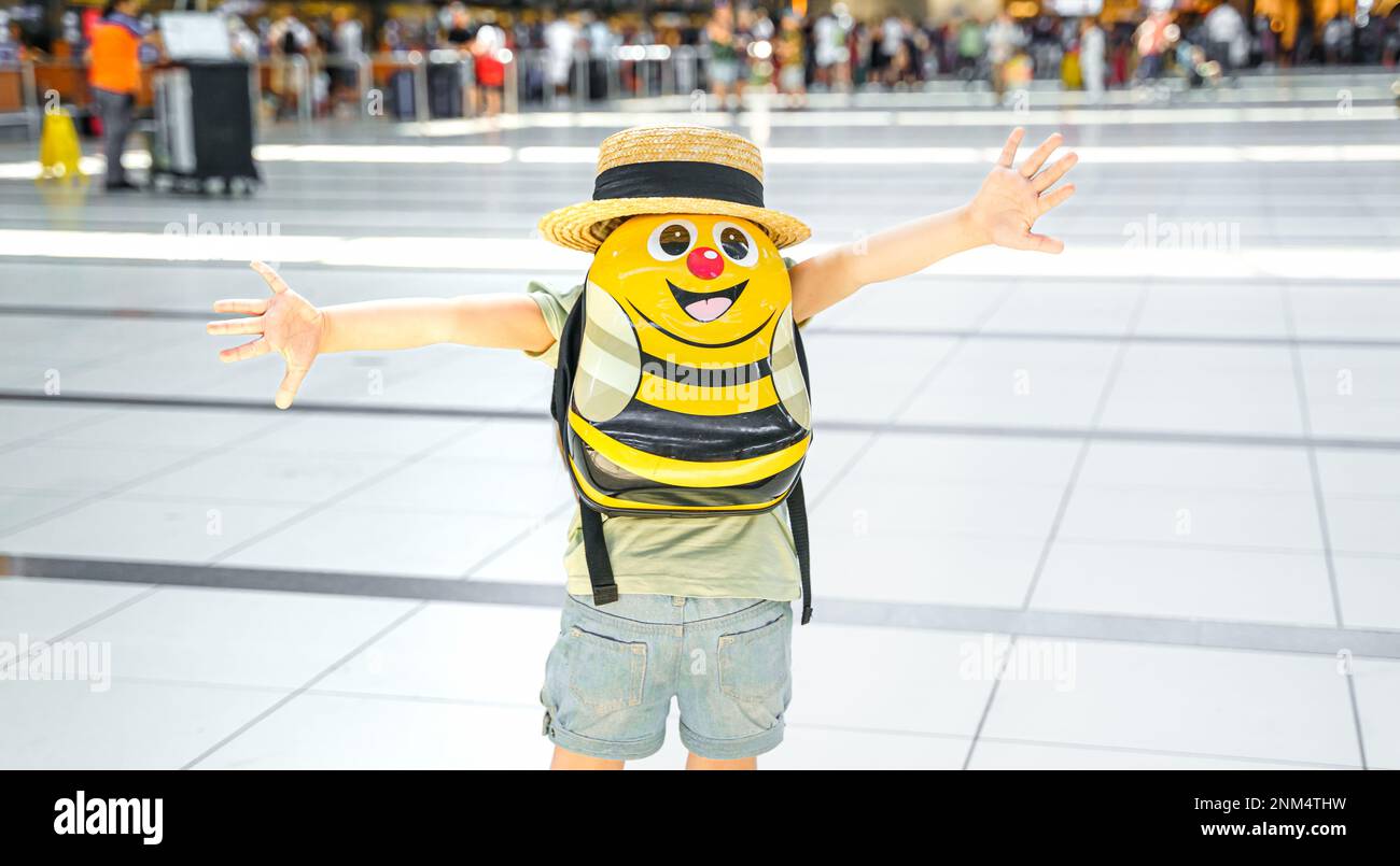 Girl with big funny backpack, bag in airport terminal. Waiting for ...