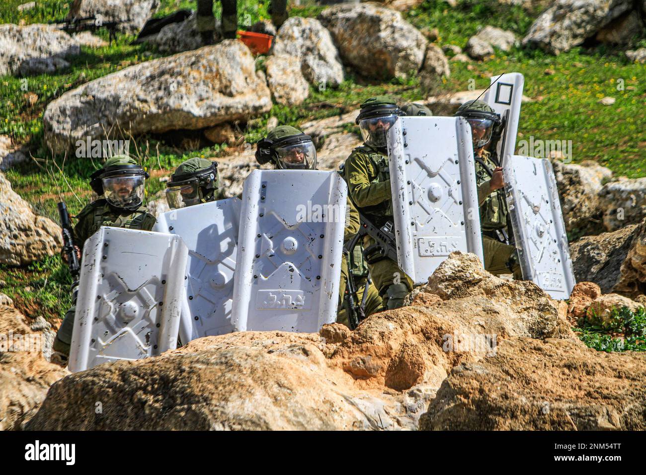 Israeli soldiers take cover behind police shields during the ...