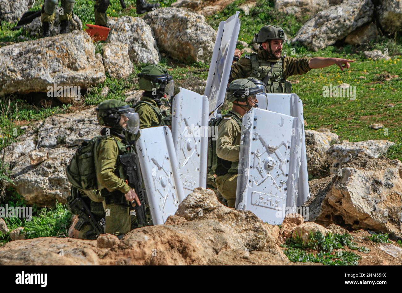 Israeli soldiers take cover behind police shields during the demonstration against Israeli ...