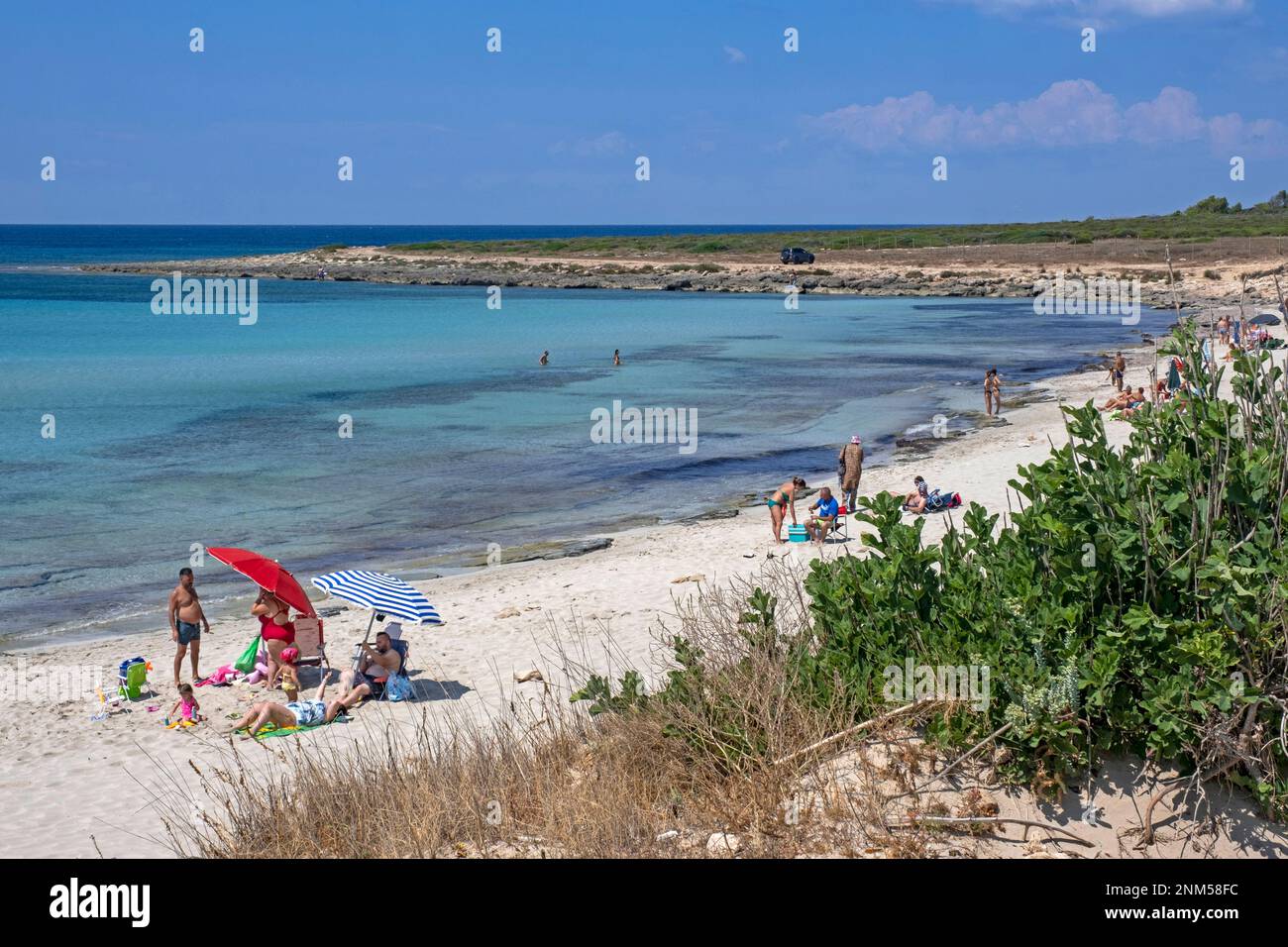 Italian tourists swimming and sunbathing on sandy beach in summer along ...