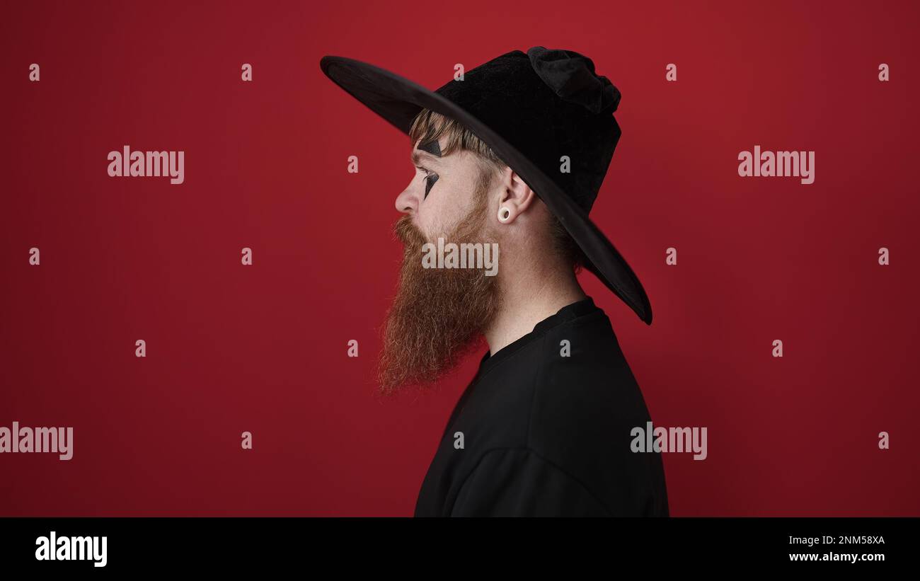 Young redhead man wearing wizard costume with relaxed expression over ...