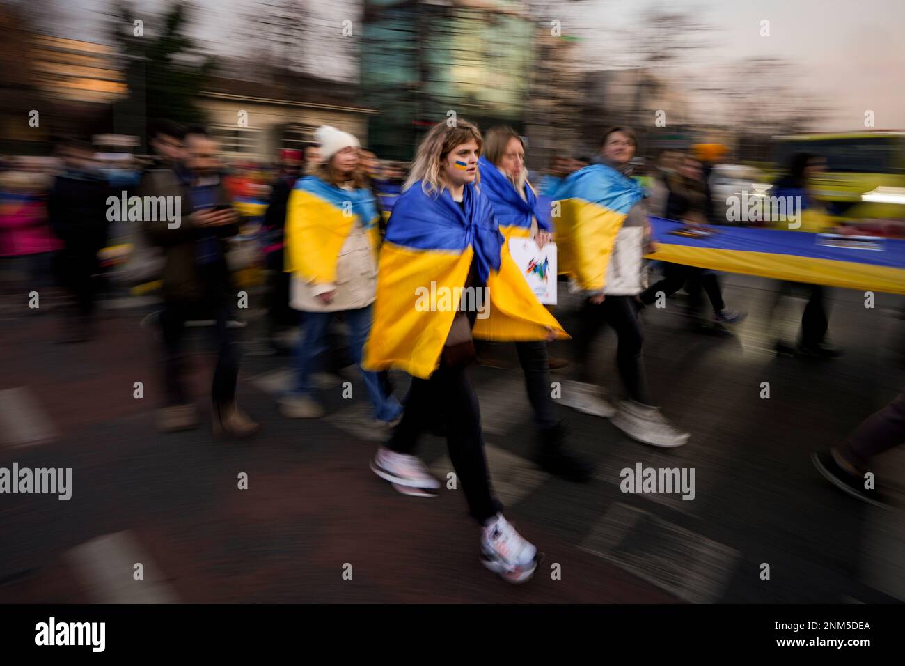 People carry a large Ukrainian flag during a protest against Russia's ...