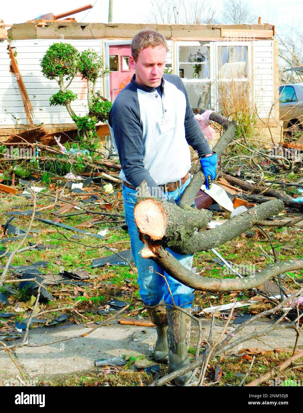 A local man helps clear tornado debris that cluttered neighbors' yards ...