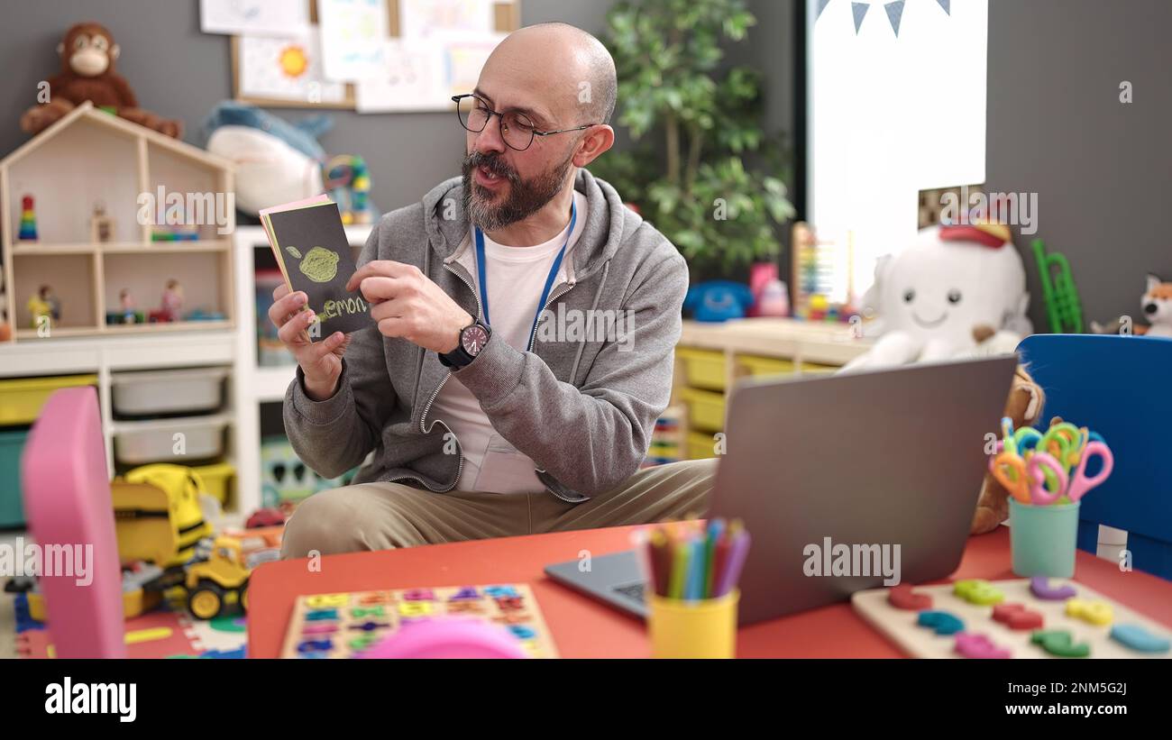 Young bald man preschool teacher teaching vocabulary lesson on video ...