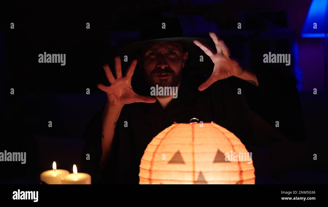 Young bald man wearing wizard costume doing magic gesture at home Stock ...