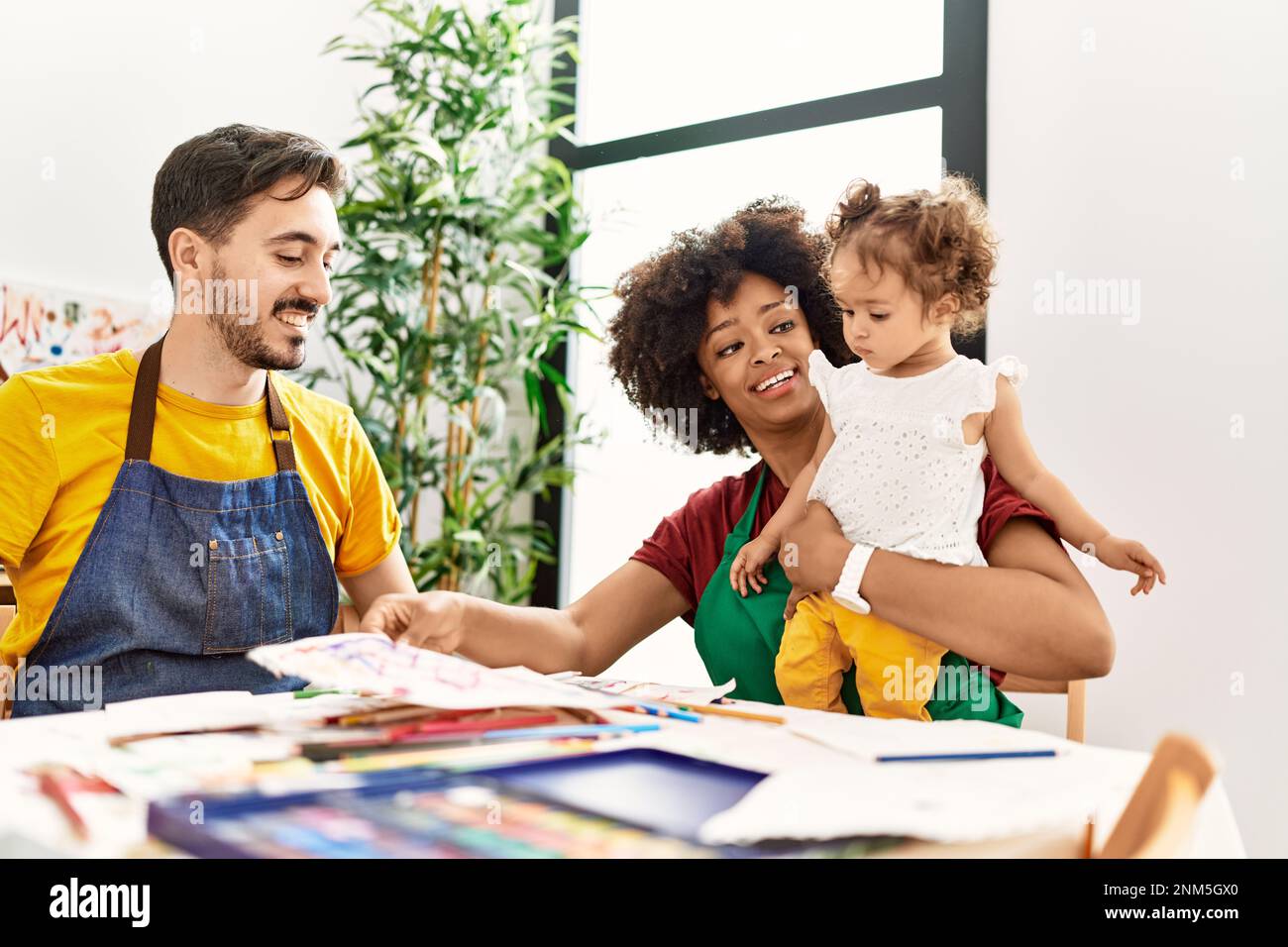 Couple and daughter smiling confident drawing at art studio Stock Photo ...