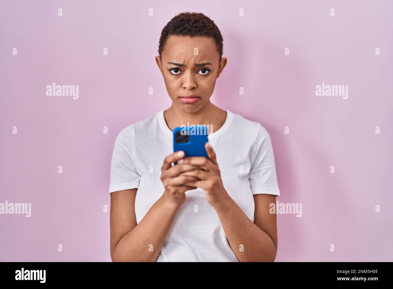 Beautiful african american woman using smartphone depressed and worry ...