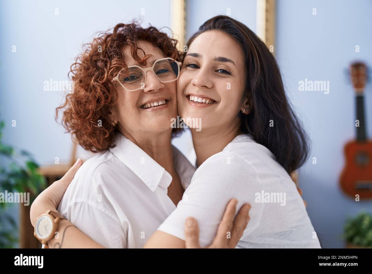 Two women mother and daughter hugging each other standing at home Stock Photo - Alamy
