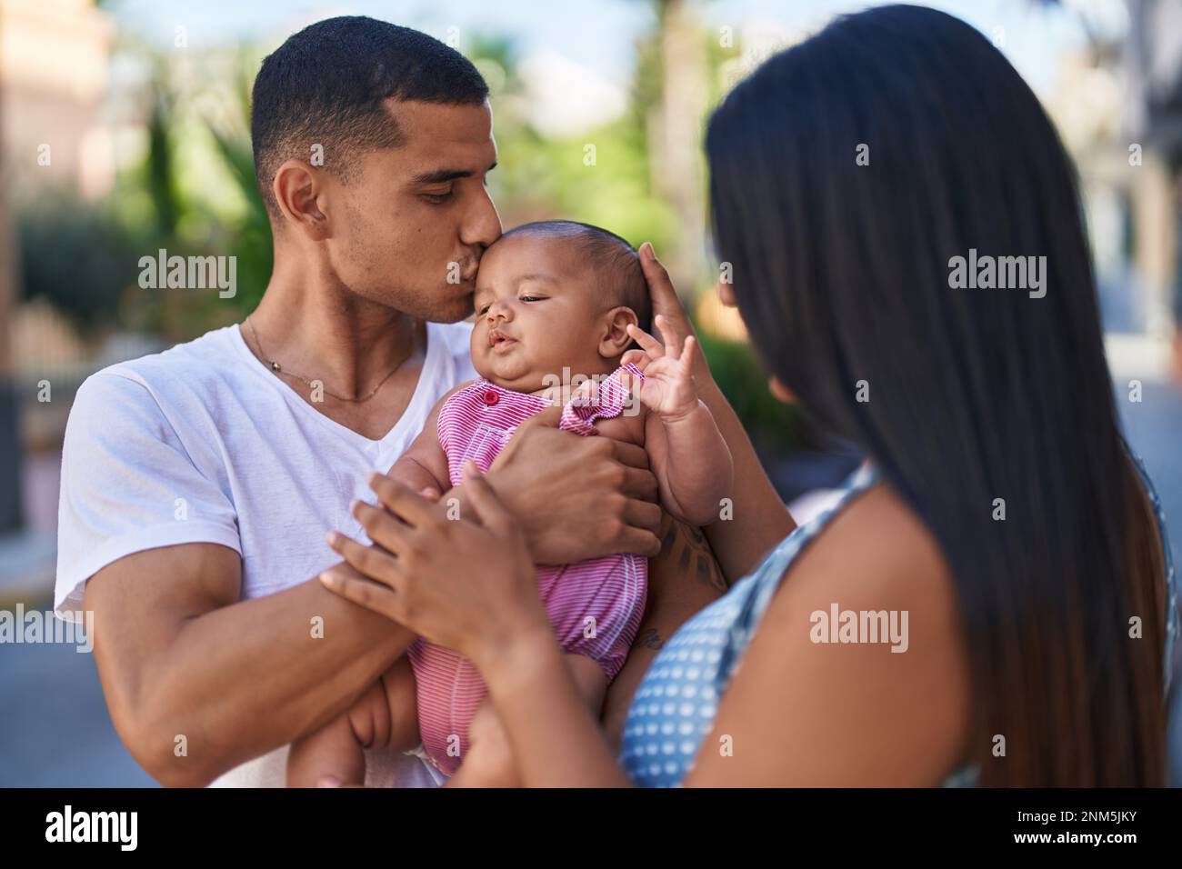 Hispanic family hugging each other kissing at street Stock Photo - Alamy