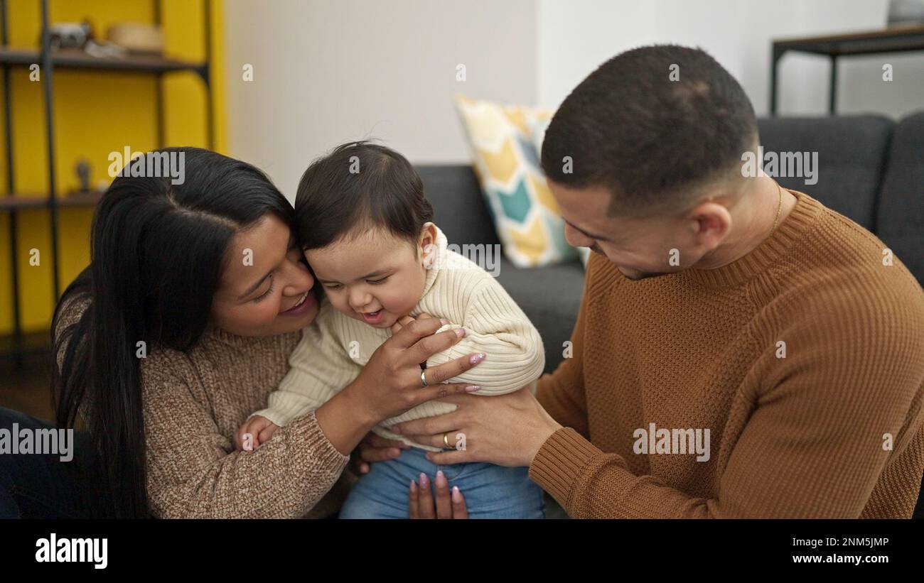 Couple and son hugging each other sitting on floor at home Stock Photo ...