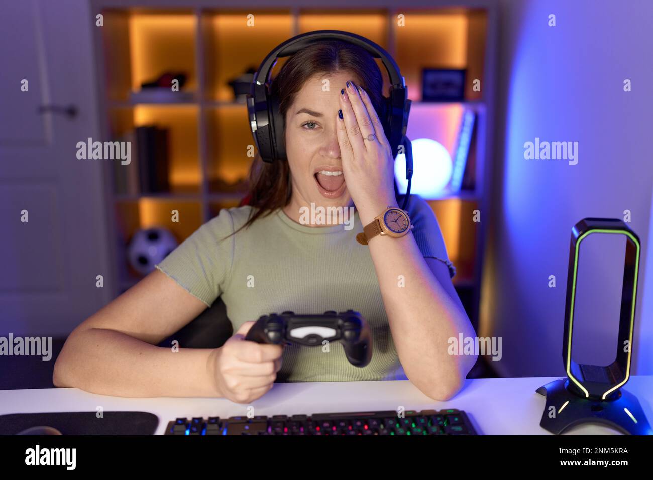 Beautiful brunette woman playing video games wearing headphones ...