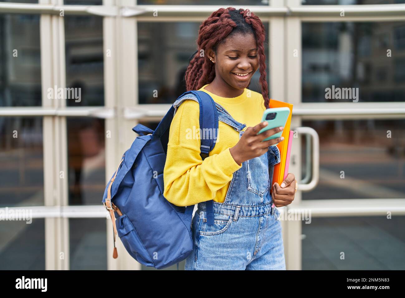 African american woman student smiling confident using smartphone at ...