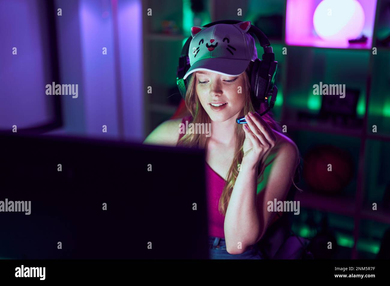 Young woman streamer using computer and headphones at gaming room Stock ...
