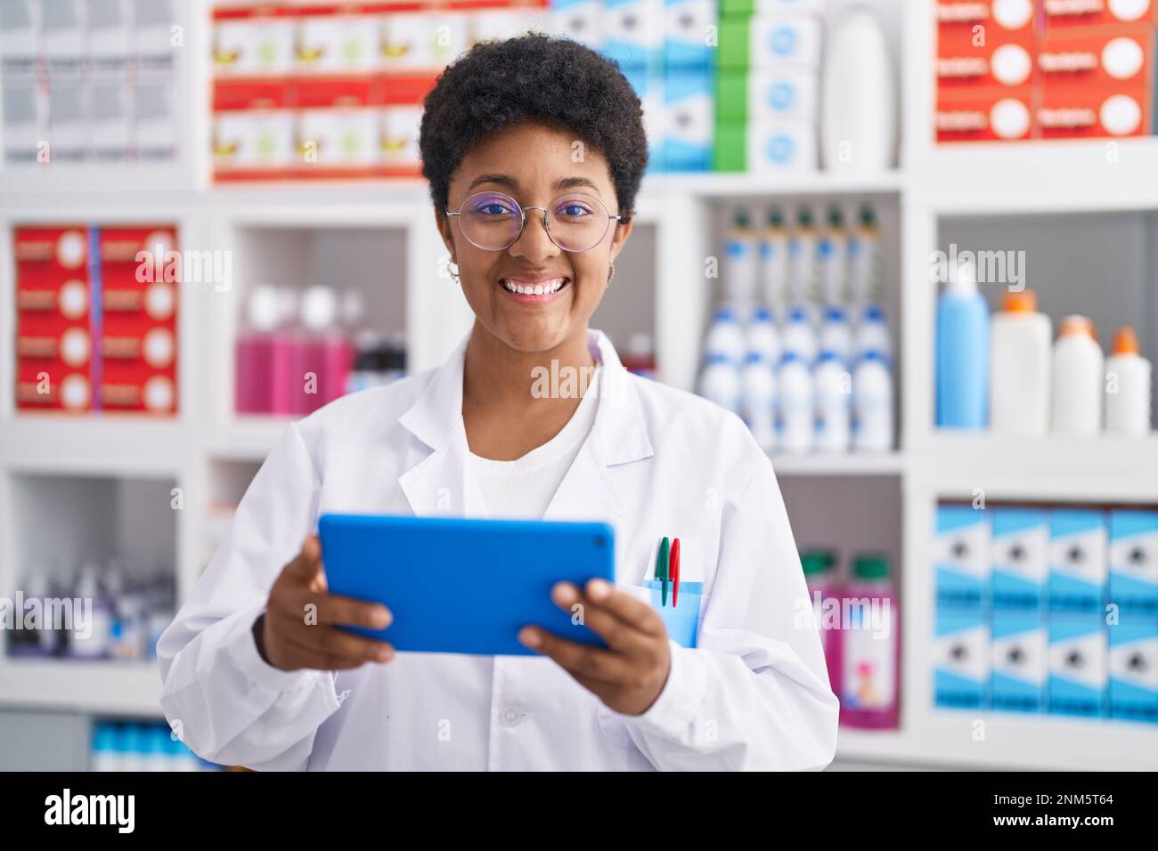 African american woman pharmacist using touchpad working at pharmacy ...
