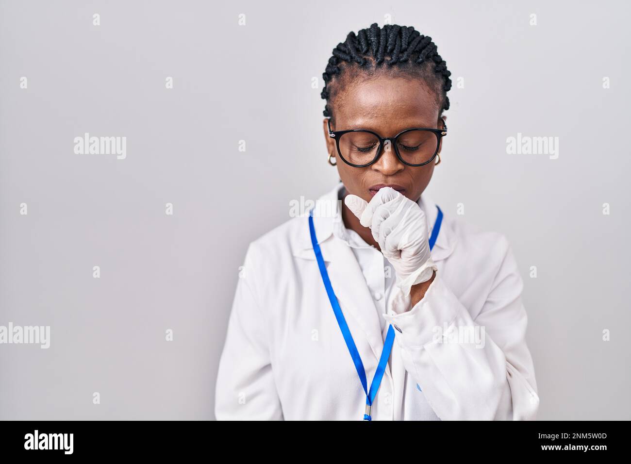 African woman with braids wearing scientist uniform feeling unwell and ...