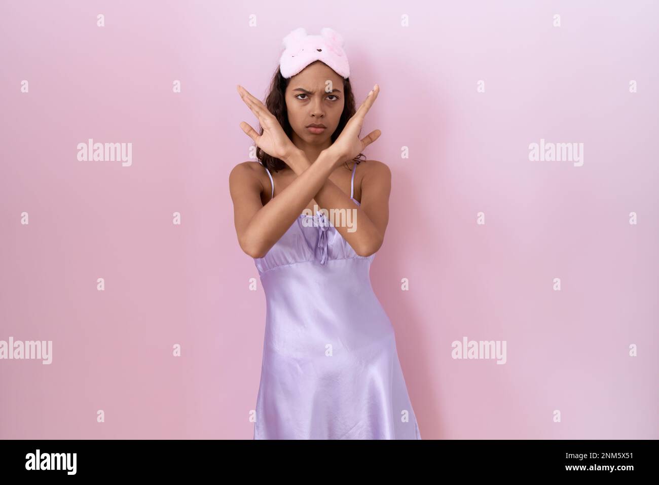Young hispanic woman wearing sleep mask and nightgown rejection ...