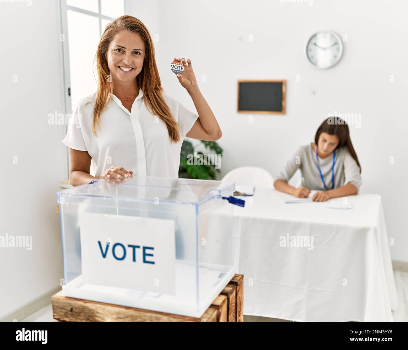 Mother and daughter smiling confident holding vote badge at electoral ...