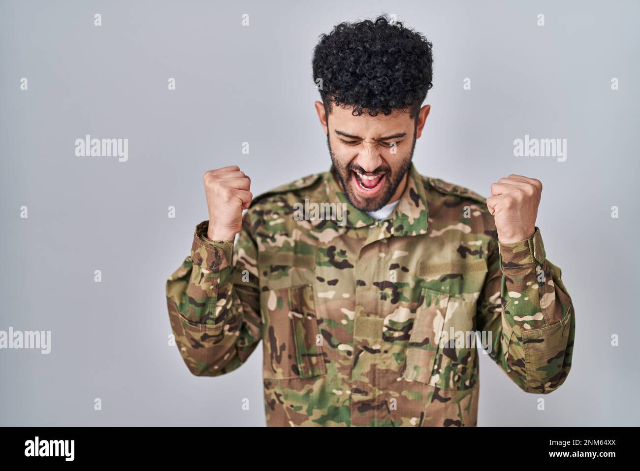 Arab man wearing camouflage army uniform celebrating mad and crazy for ...