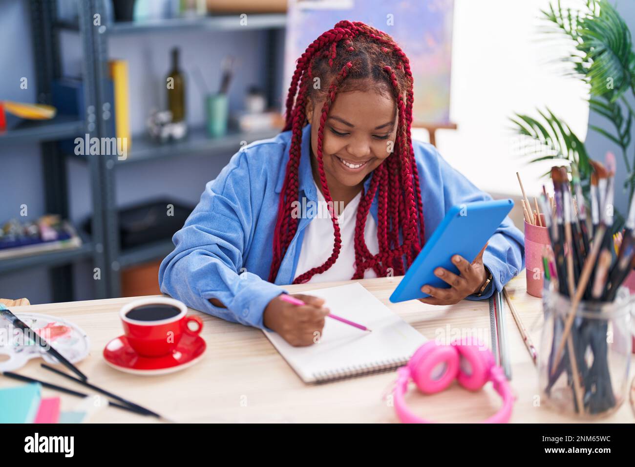 African american woman artist using touchpad drawing on notebook at art ...