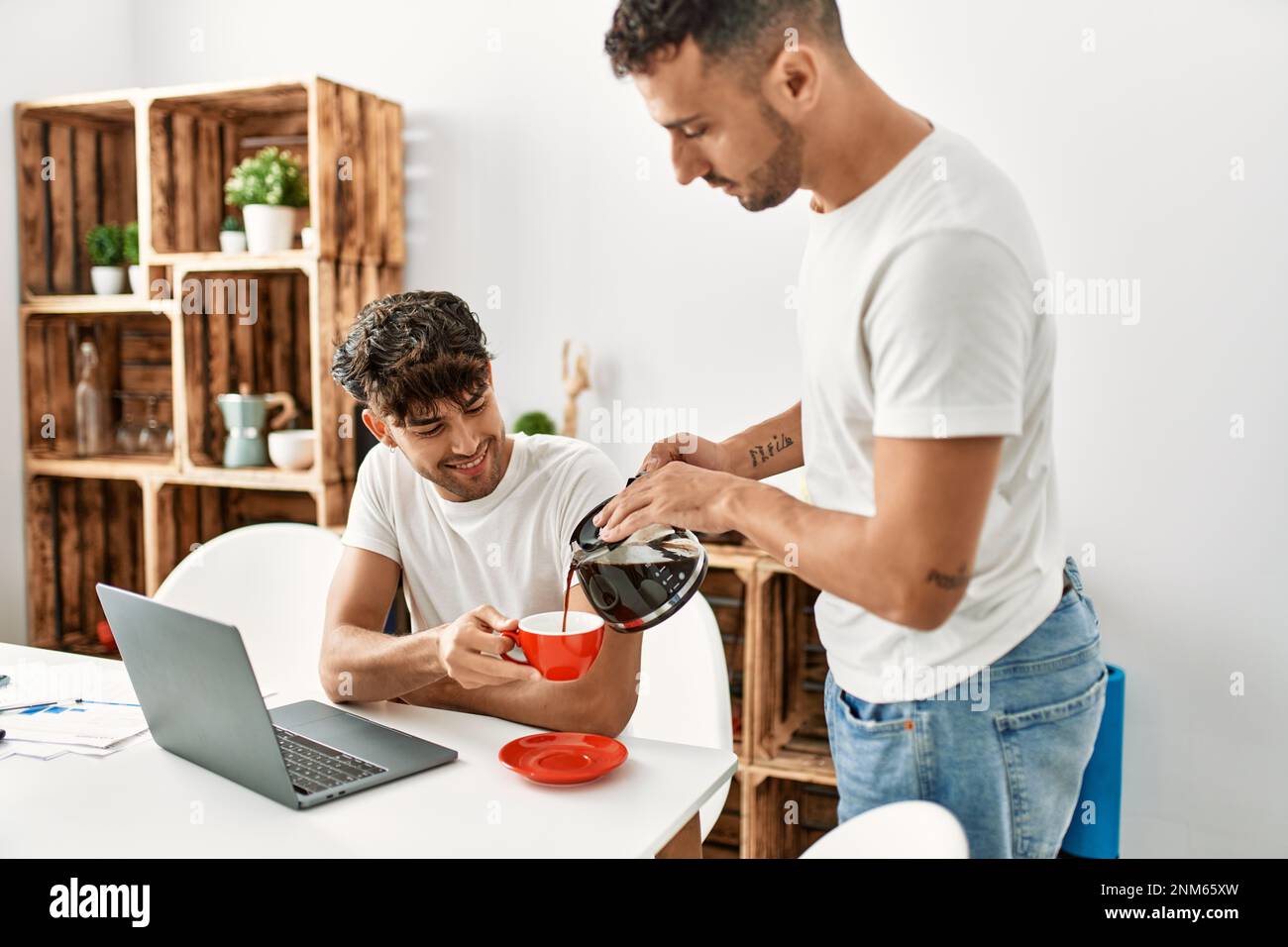 Two hispanic men couple pouring coffee having breakfast at home Stock ...