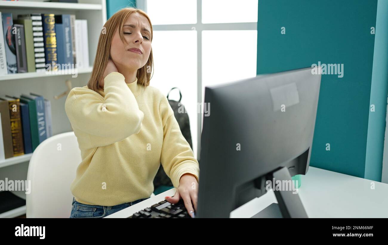 Young blonde woman student using computer stressed at university ...